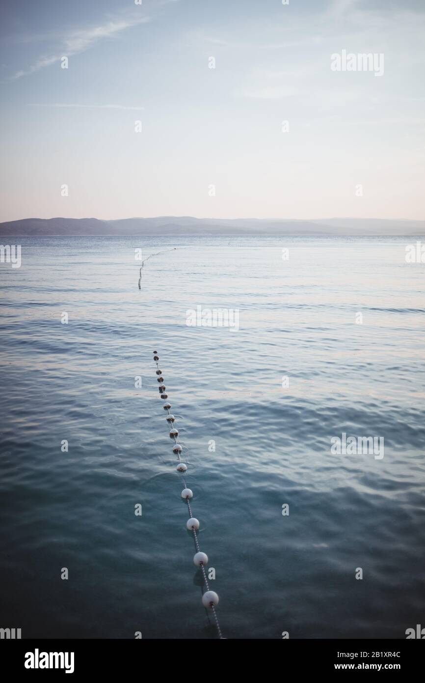 Calm background with views of the sea and the far shore. dividing buoys ...