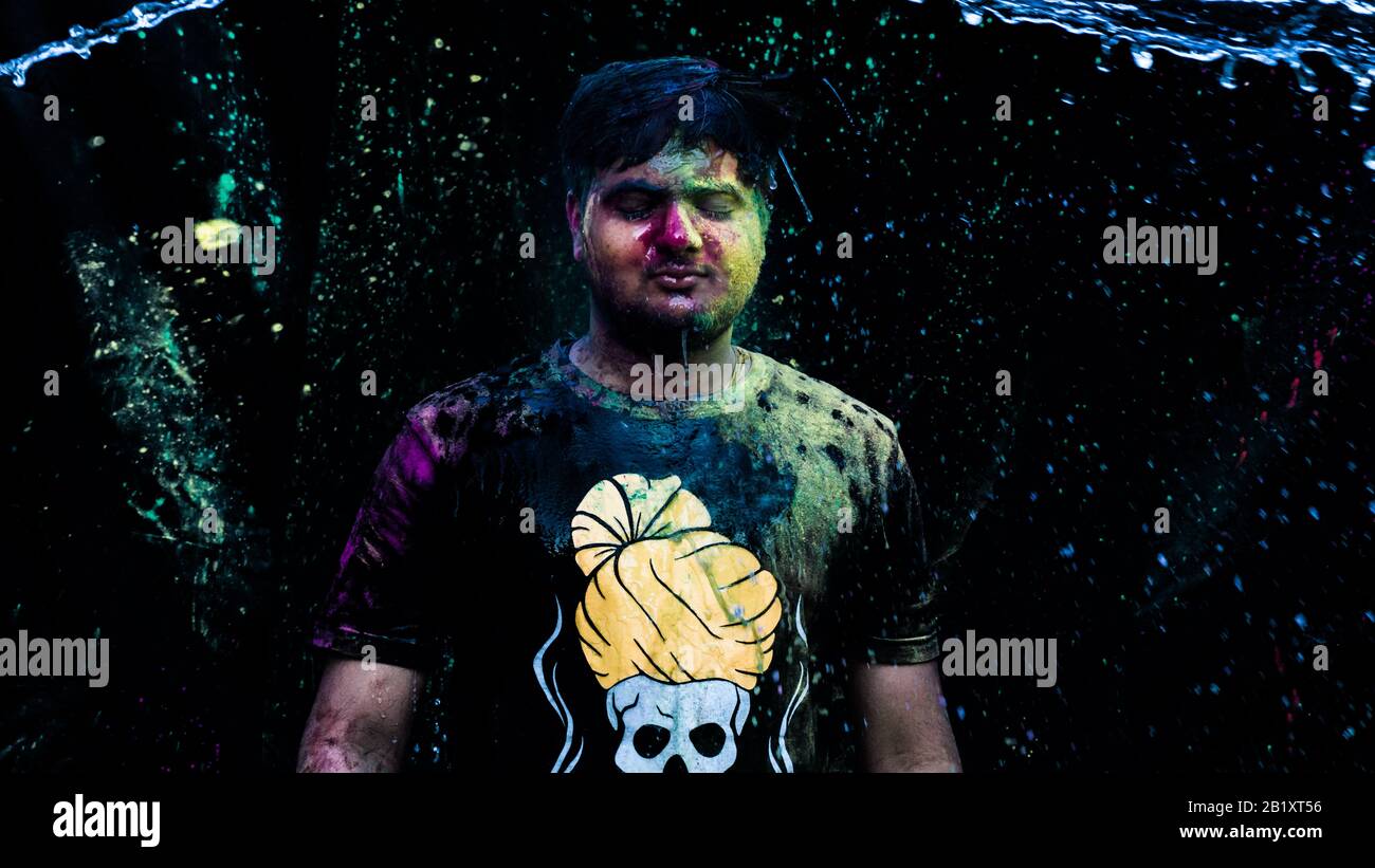 Young man playing holi with water. water splashing on his face. holi is ...