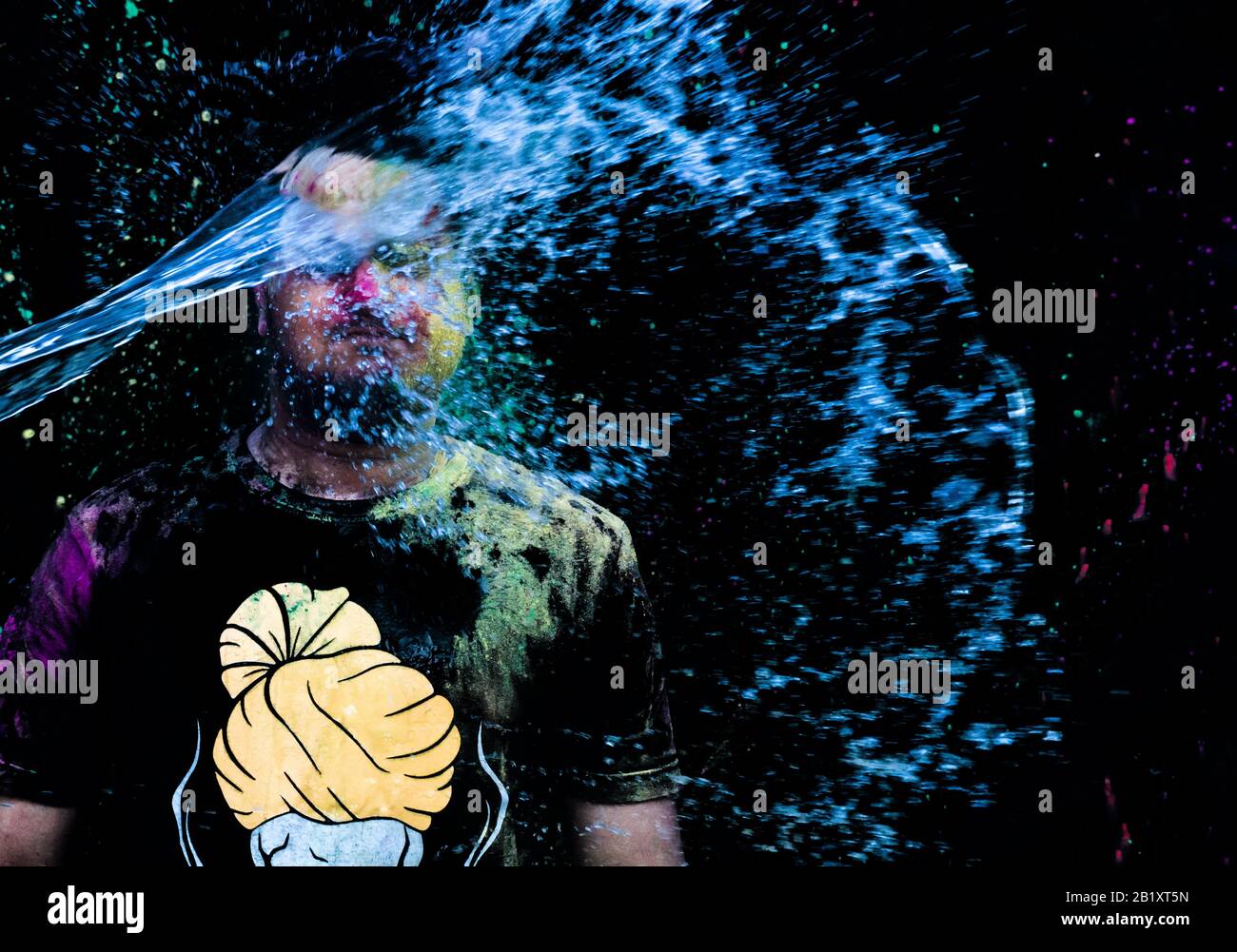 Young man playing holi with water. water splashing on his face. holi is ...