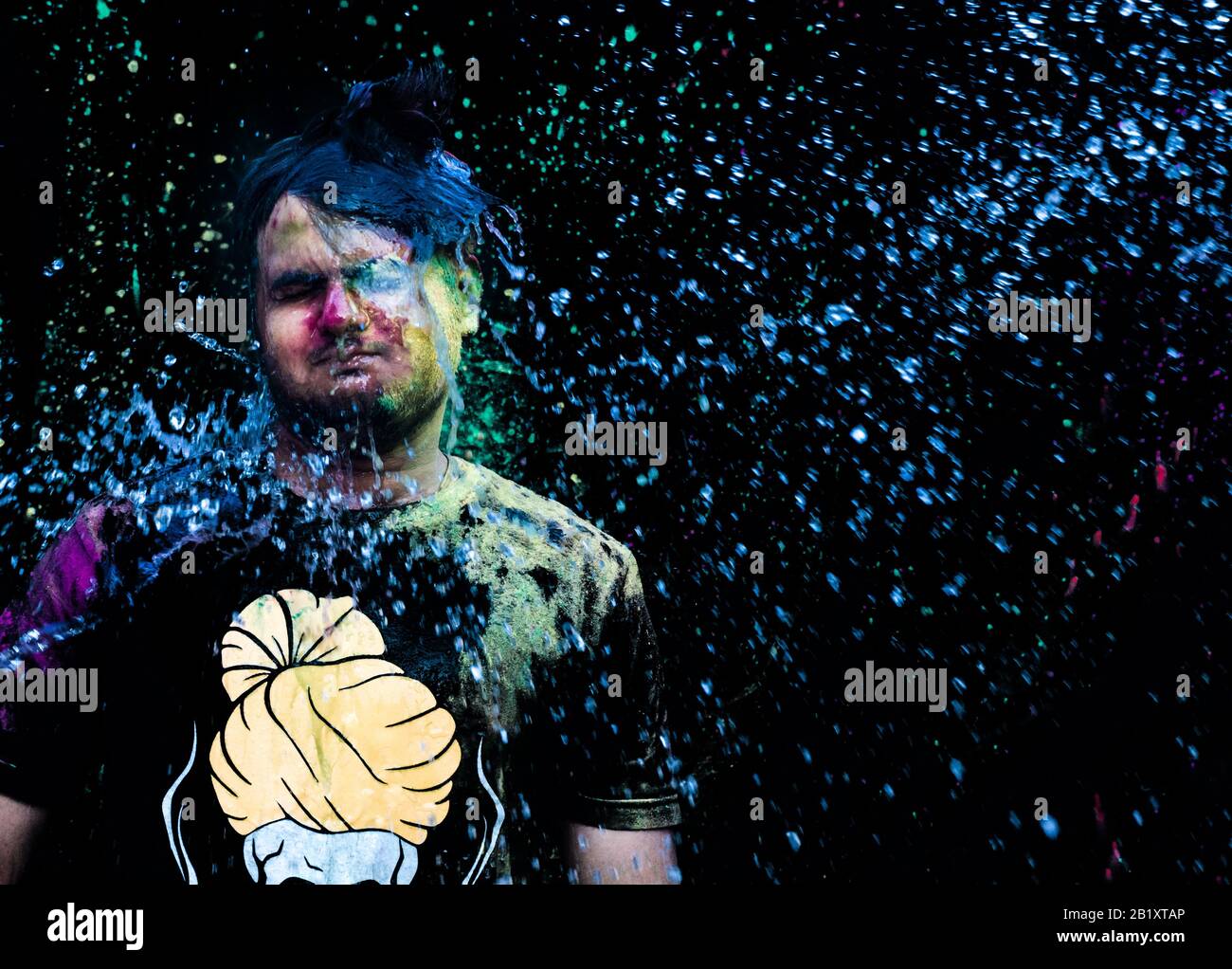 Young man playing holi with water. water splashing on his face. holi is ...