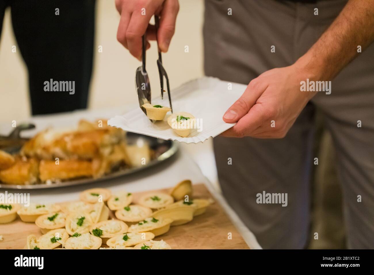 Man serving himself with vegetarian canapes at celebration event Stock ...