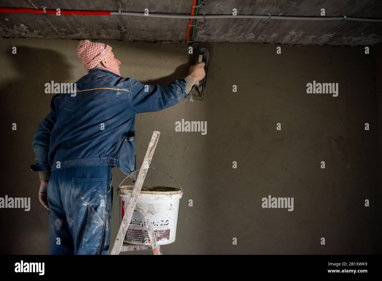Construction worker plastering interior wall using cement plaster ...