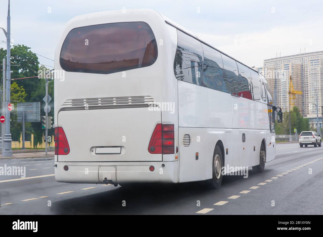 white tourist bus goes on the city street Stock Photo - Alamy