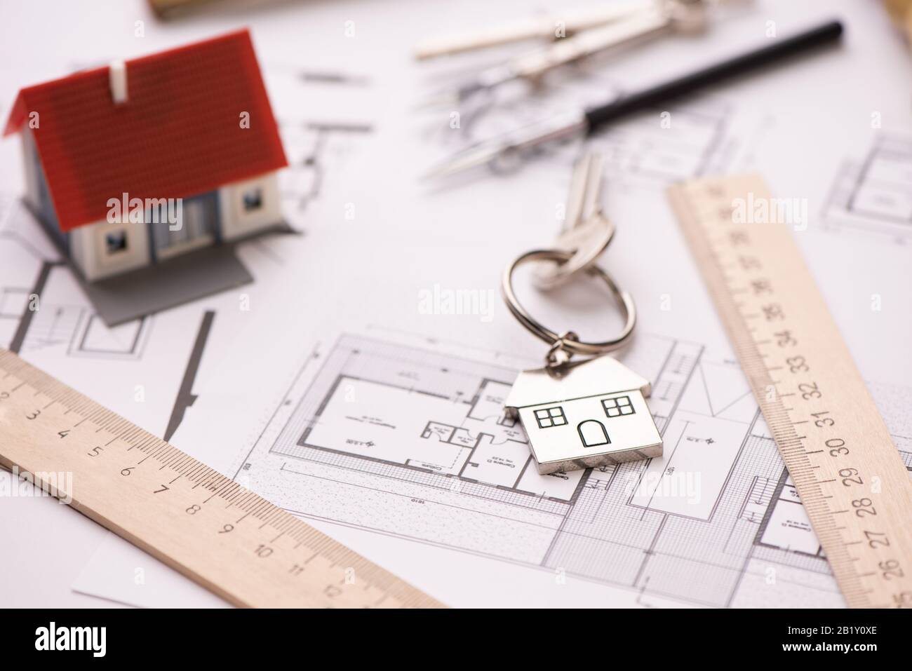 A model house on blueprints with keys to the new home Close up Stock ...