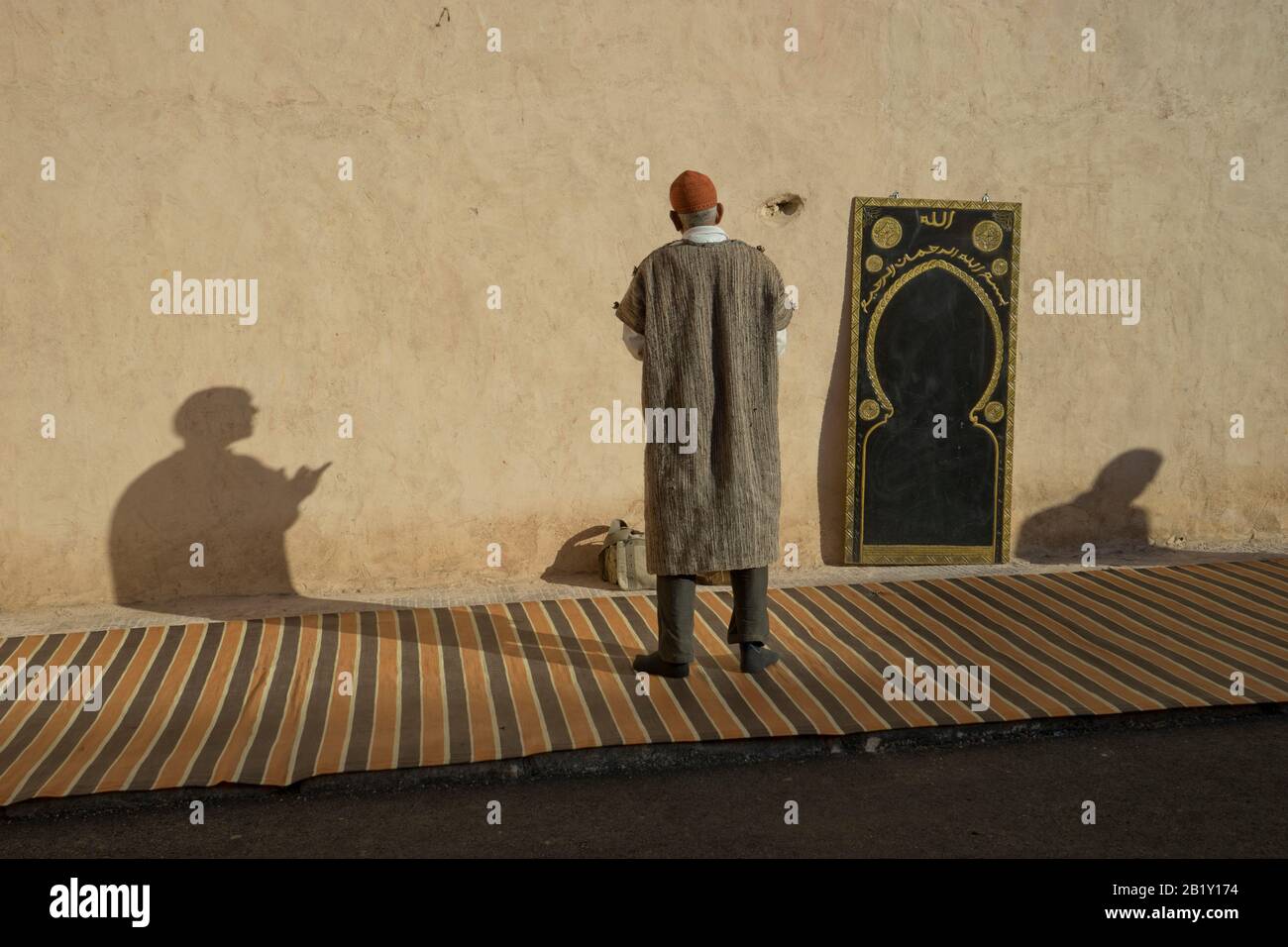 Muslim man praying by city walls in the afternoon in Marrakesh,Morocco ...