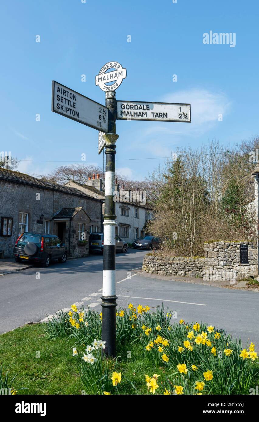 Spring photo of an old style black and white road sign in the centre of ...