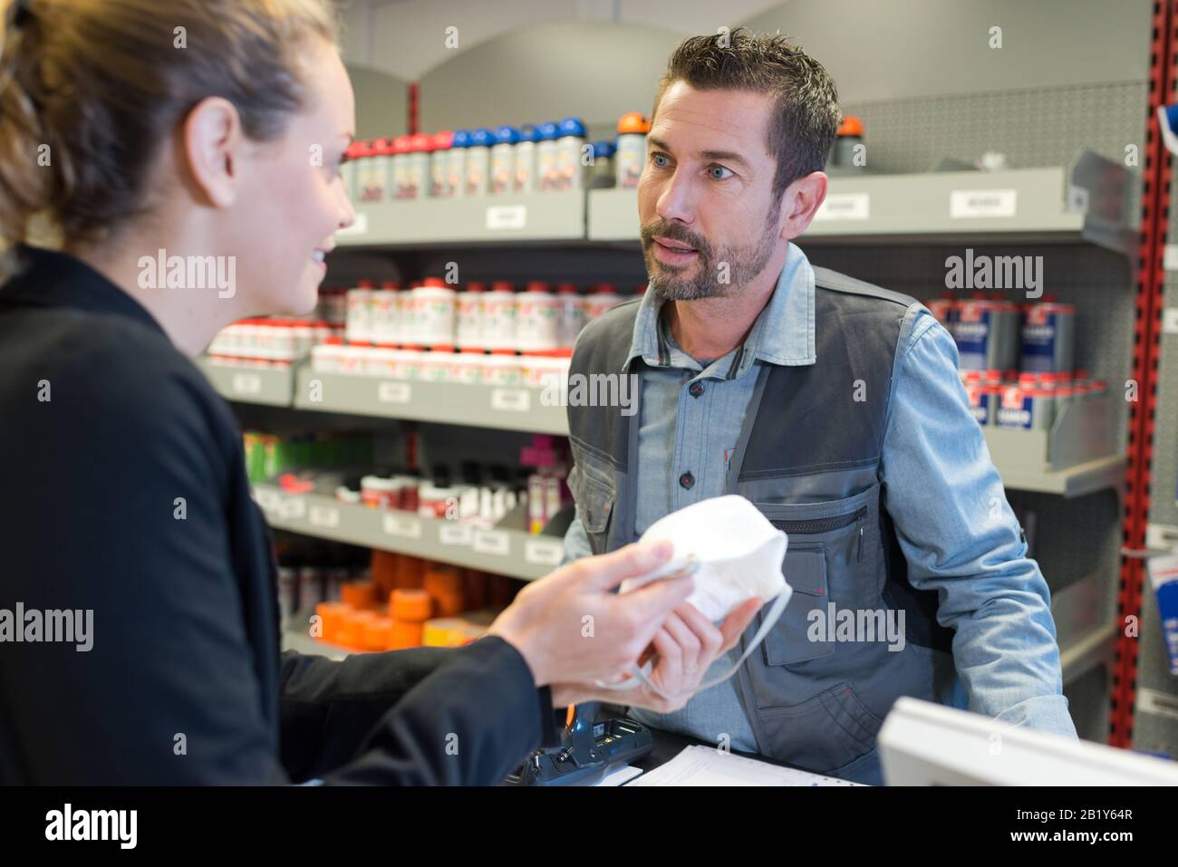 female shop assistant talking to customer Stock Photo - Alamy