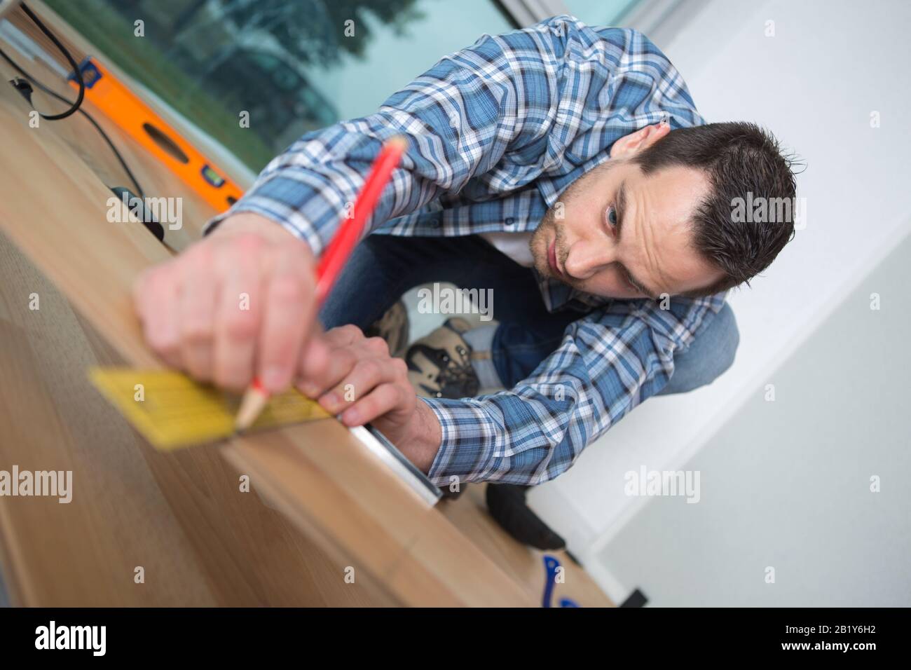 man using tape measure to measure flooring and marking position Stock ...