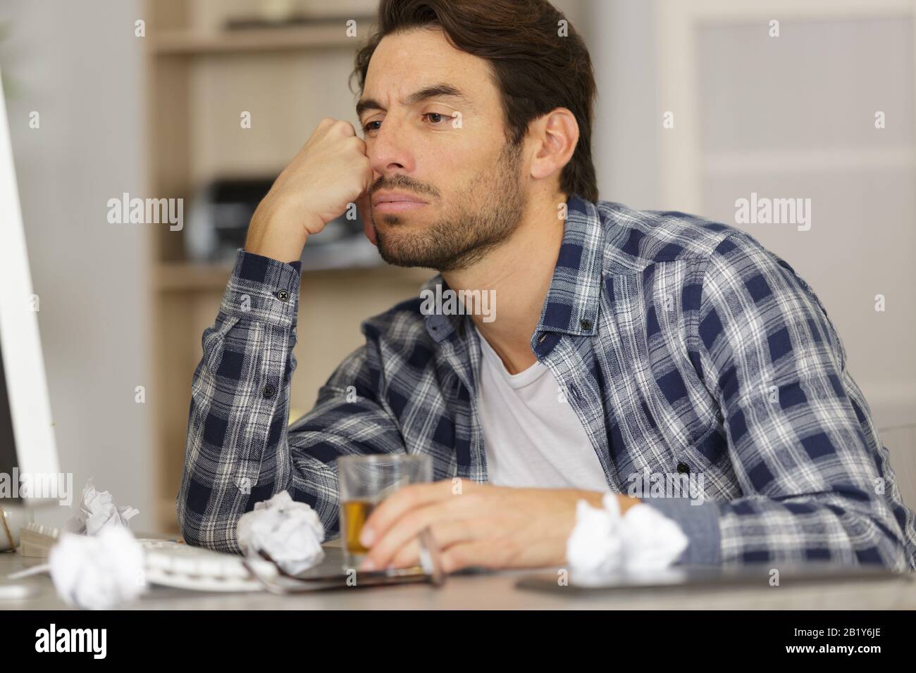 bored man with drink sat in front of his computer Stock Photo - Alamy