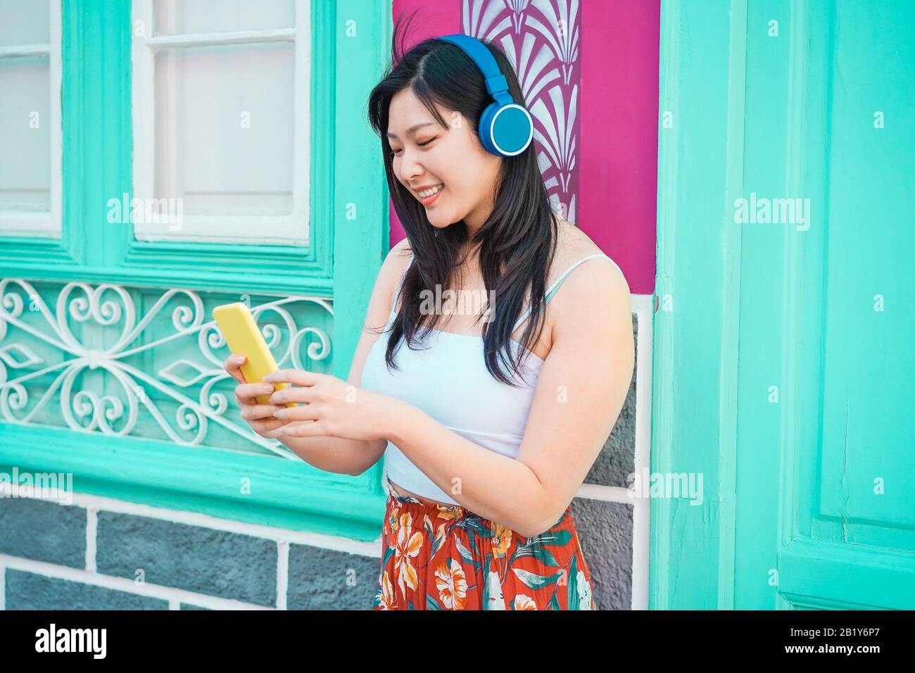 Asian social influencer woman listening music with smartphone app ...