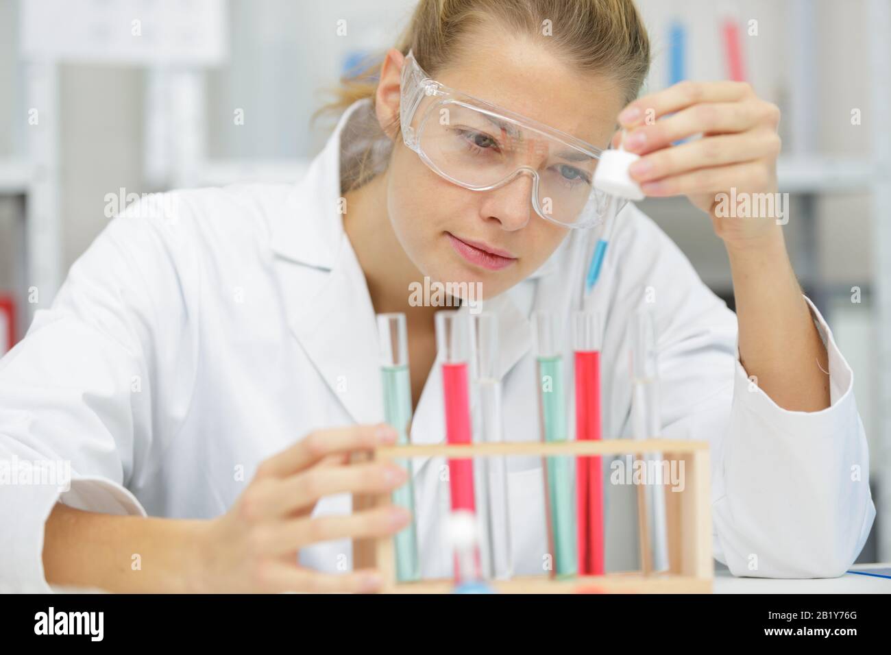 attractive female scientist load liquid sample substance probe in lab ...