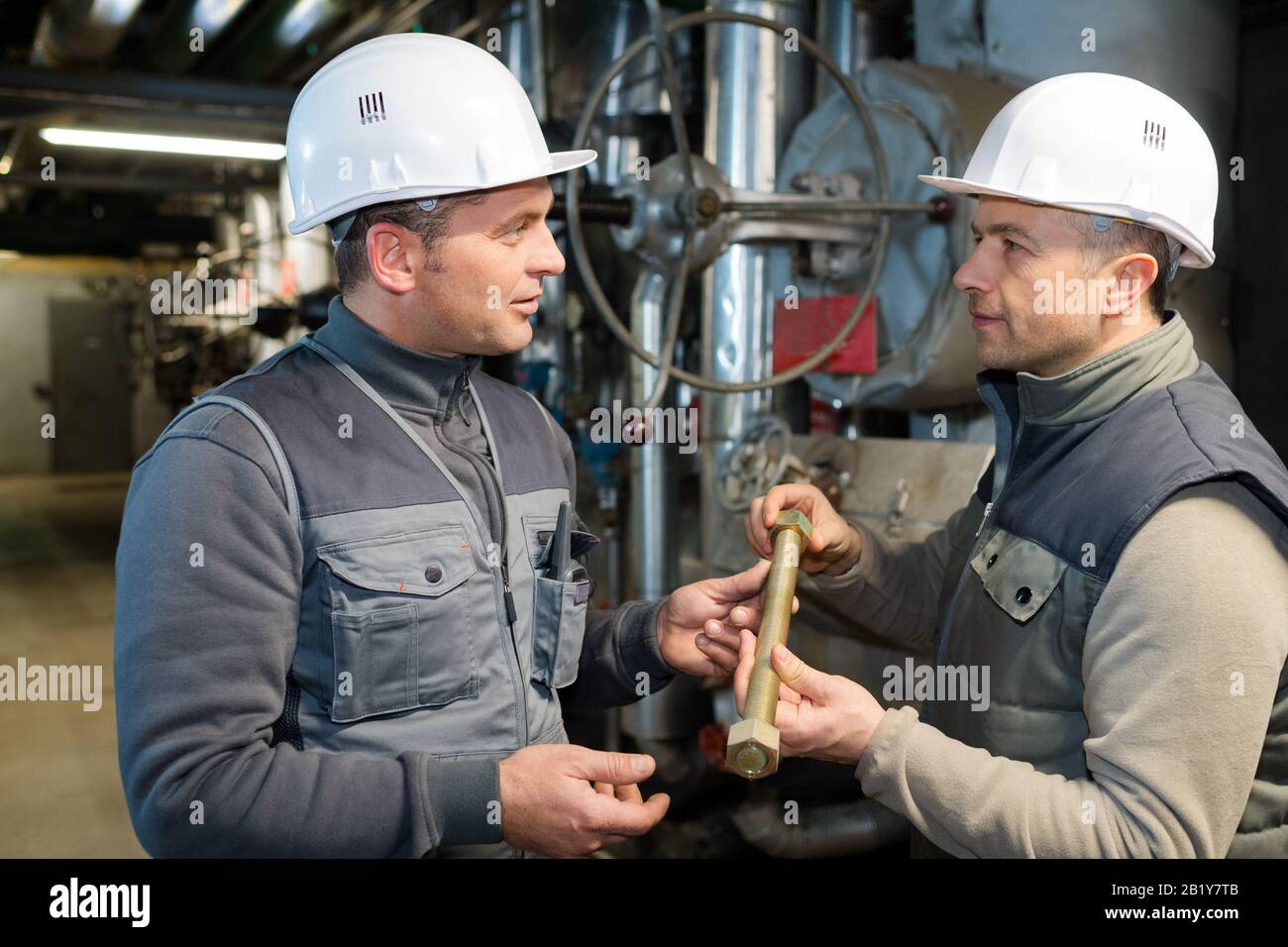 two mechanics are talking in factory Stock Photo - Alamy