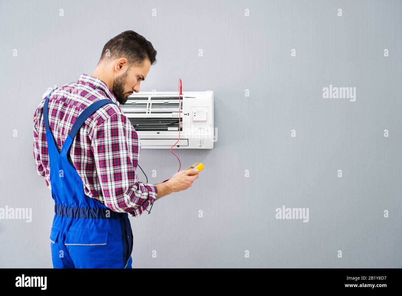 Portrait Of A Mid-adult Male Technician Testing Air Conditioner With ...