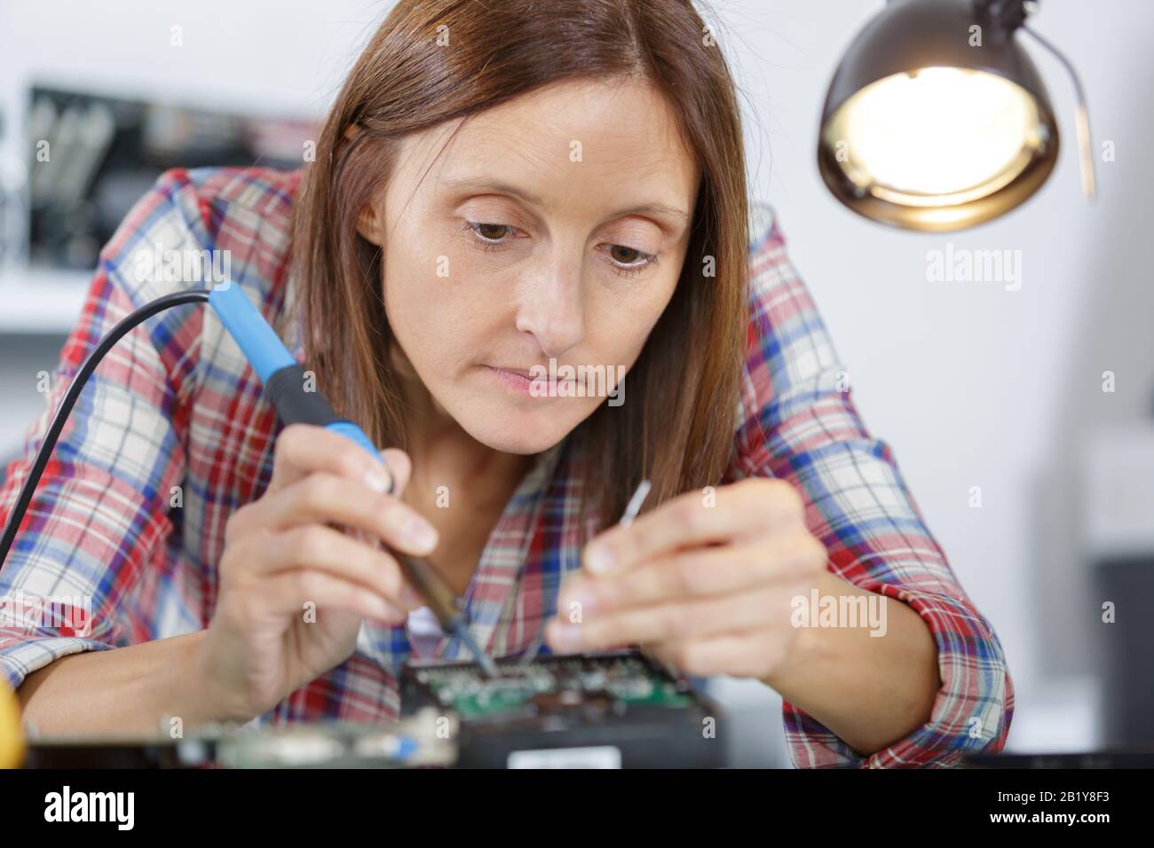 a female pc technician soldering pc part Stock Photo - Alamy