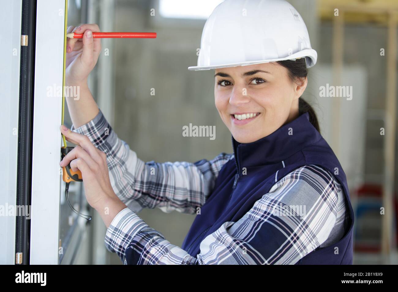 a female builder measuring window Stock Photo - Alamy