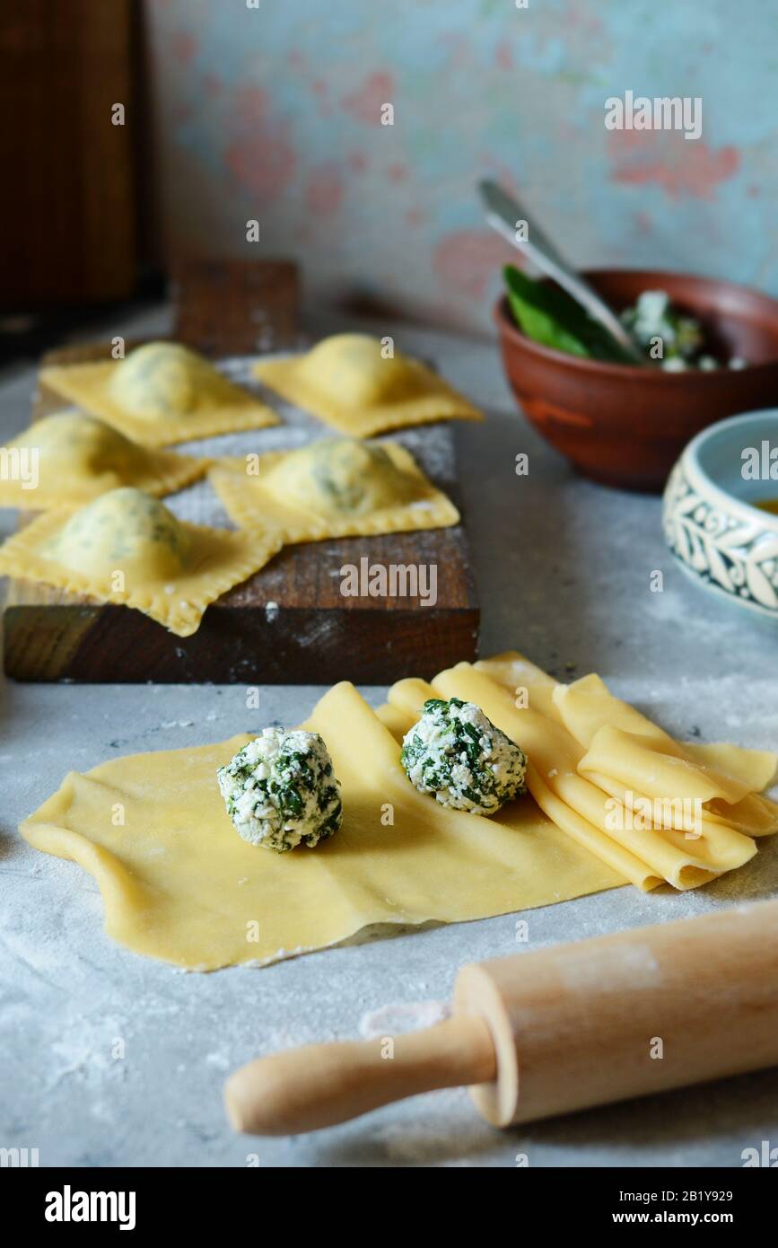 Fresh Raw Ravioli with Ricotta and Spinach on a blue background ...