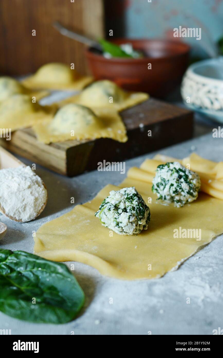 Fresh Raw Ravioli with Ricotta and Spinach on a blue background ...