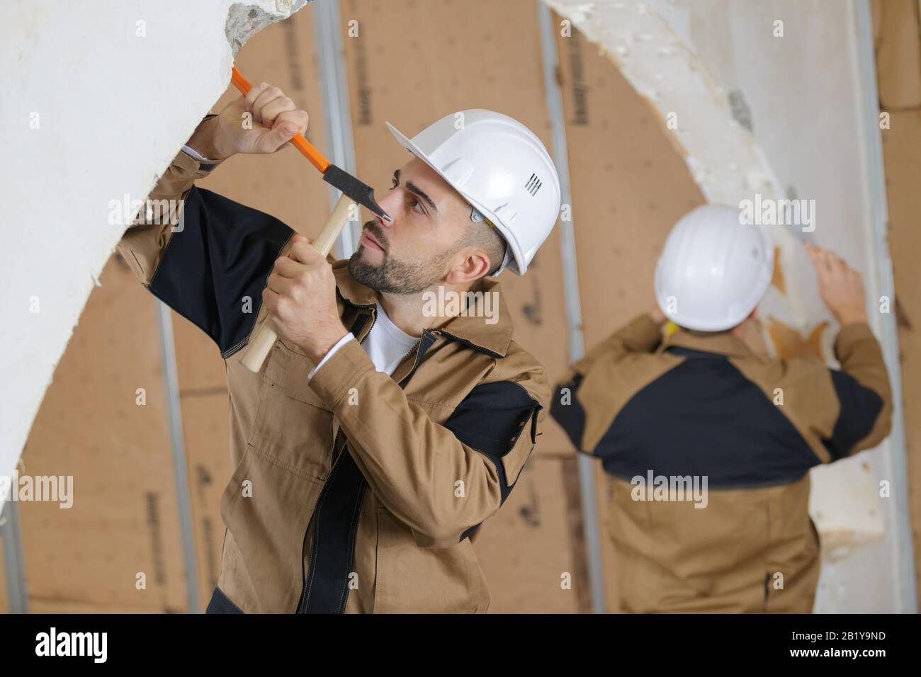 young builder holding chisel and hammer Stock Photo - Alamy