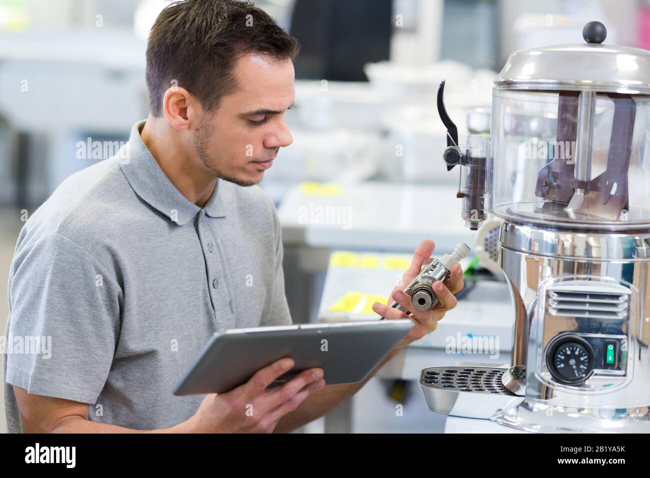 salesman with tablet inspecting coffee machine Stock Photo - Alamy