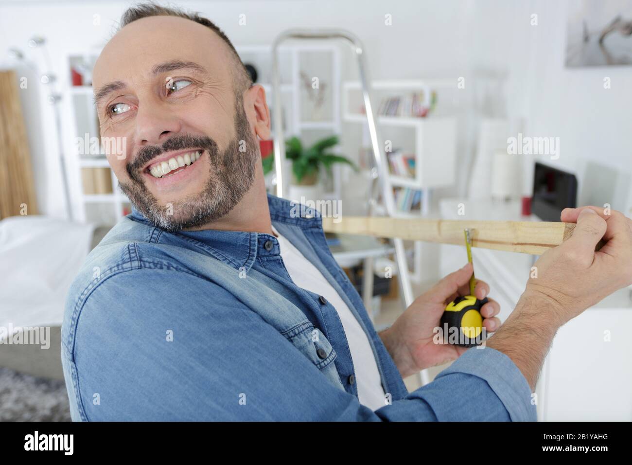 handyman laughing as he works with wood Stock Photo - Alamy