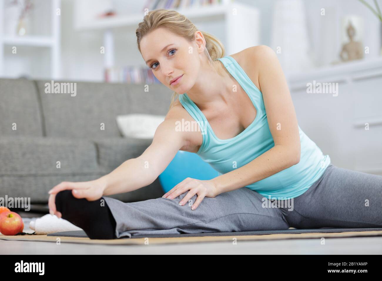 fit girl in black tracksuit stretching legs indoors Stock Photo - Alamy