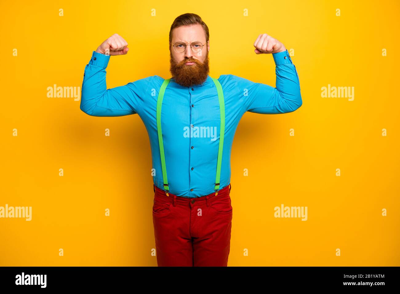 Photo of attractive funny guy seriously raise fists arms presenting ...