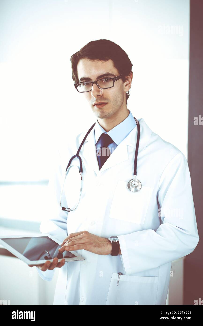 Doctor man using tablet computer for network research or virtual ...