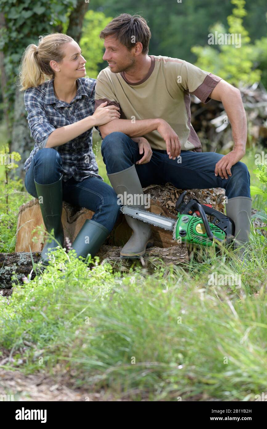 couple in the woods with a chainsaw taking a break Stock Photo - Alamy
