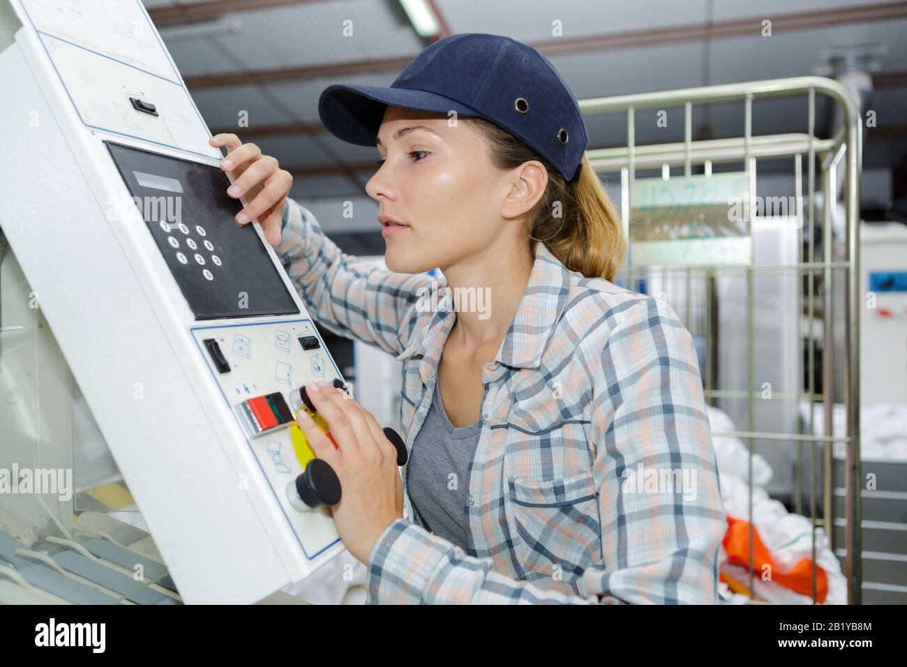 female worker operating a machine in a factory Stock Photo - Alamy