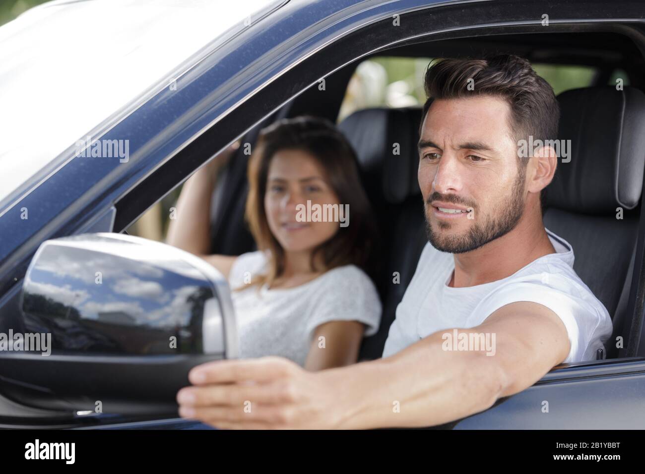happy male correcting side mirror in car Stock Photo - Alamy