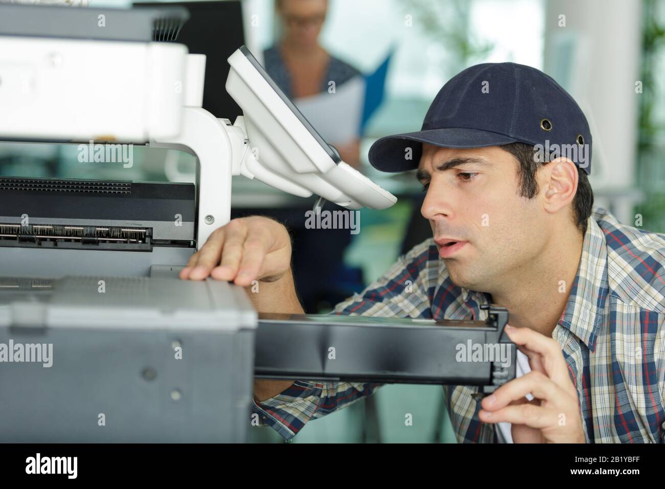 man fixing a printing machine Stock Photo - Alamy