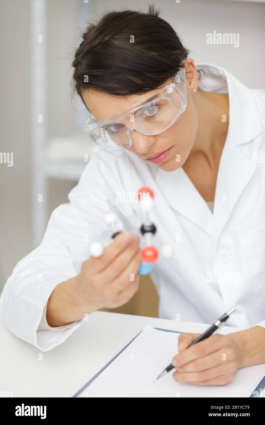 female scientist looking at dna model Stock Photo - Alamy