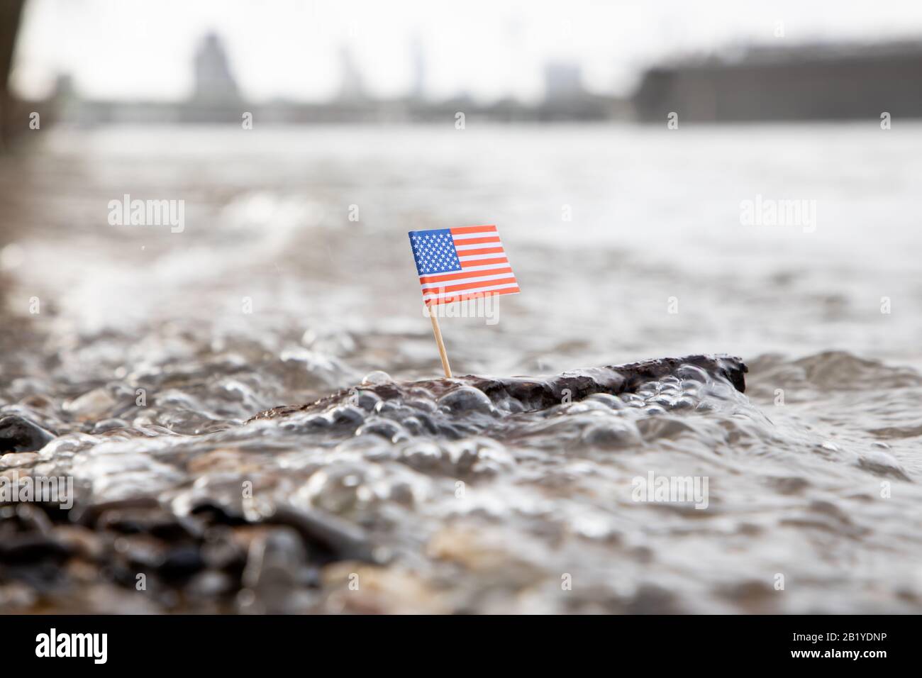 US Flag sticking in a piece of wood floating on rough sea Stock Photo ...