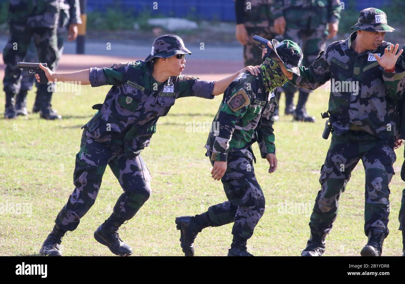 In-service policemen pointing their service weapon while on maneuver ...