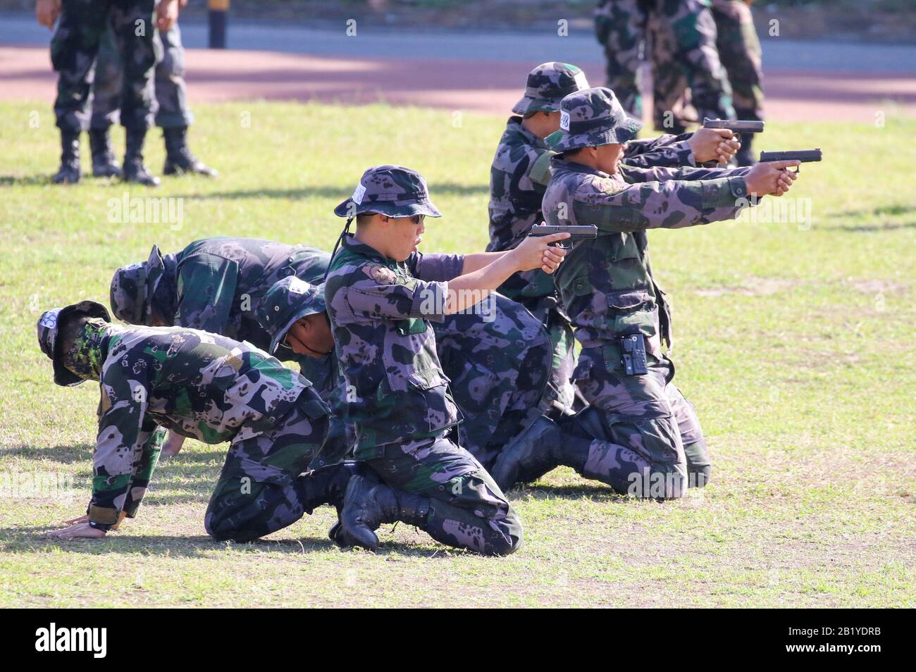 In-service policemen pointing their service weapon while on maneuver ...
