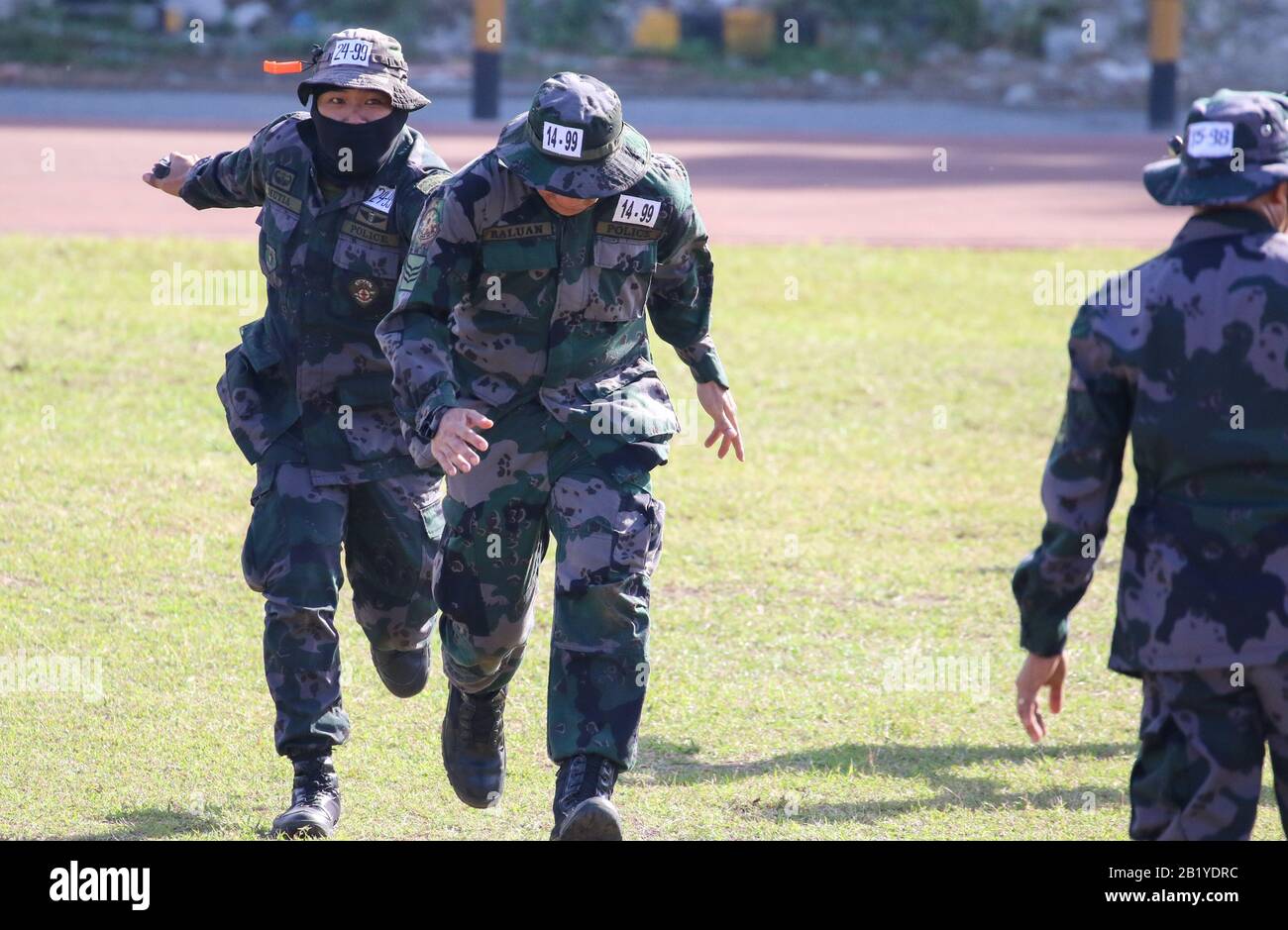 In-service policemen pointing their service weapon while on maneuver ...