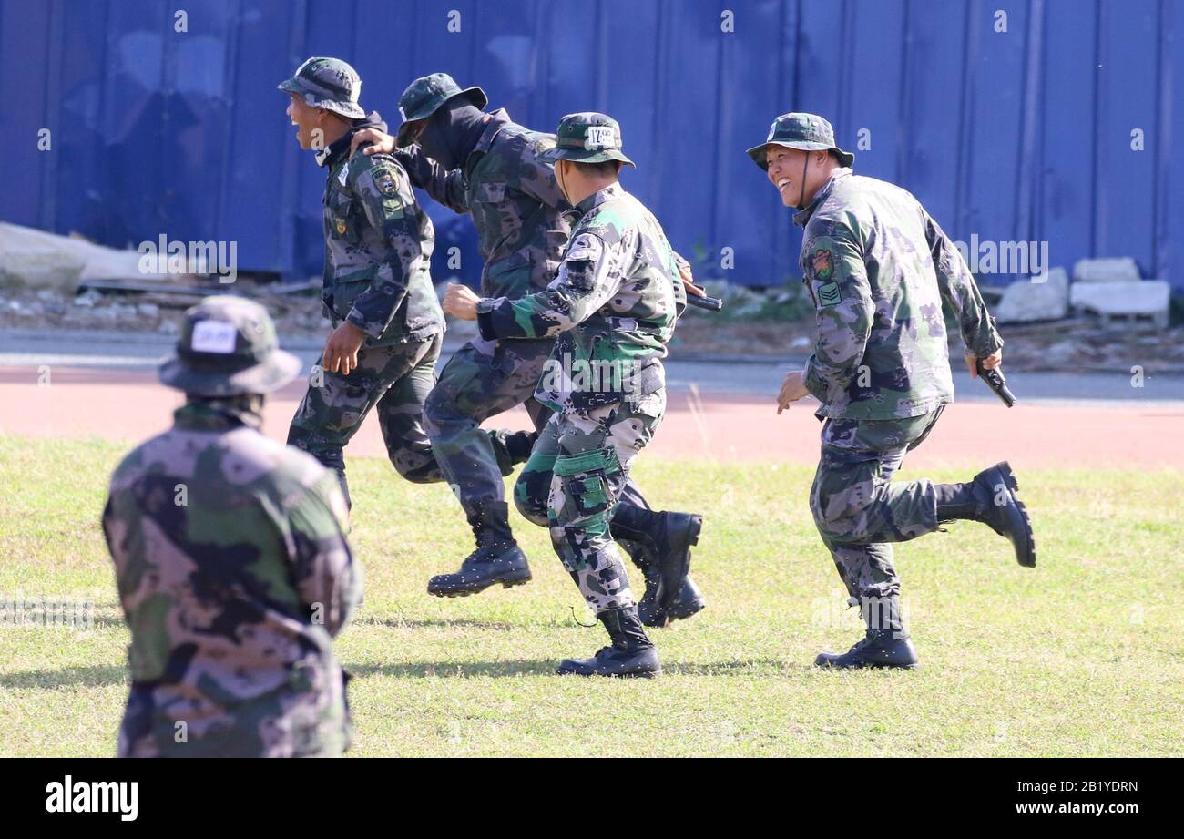In-service policemen pointing their service weapon while on maneuver ...