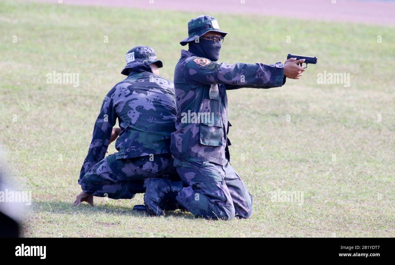 In-service policemen pointing their service weapon while on maneuver ...