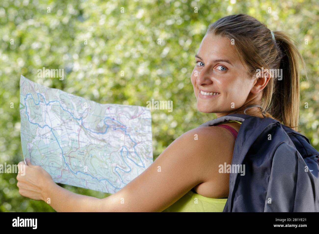 portrait of a young woman with backpack reading a map Stock Photo - Alamy