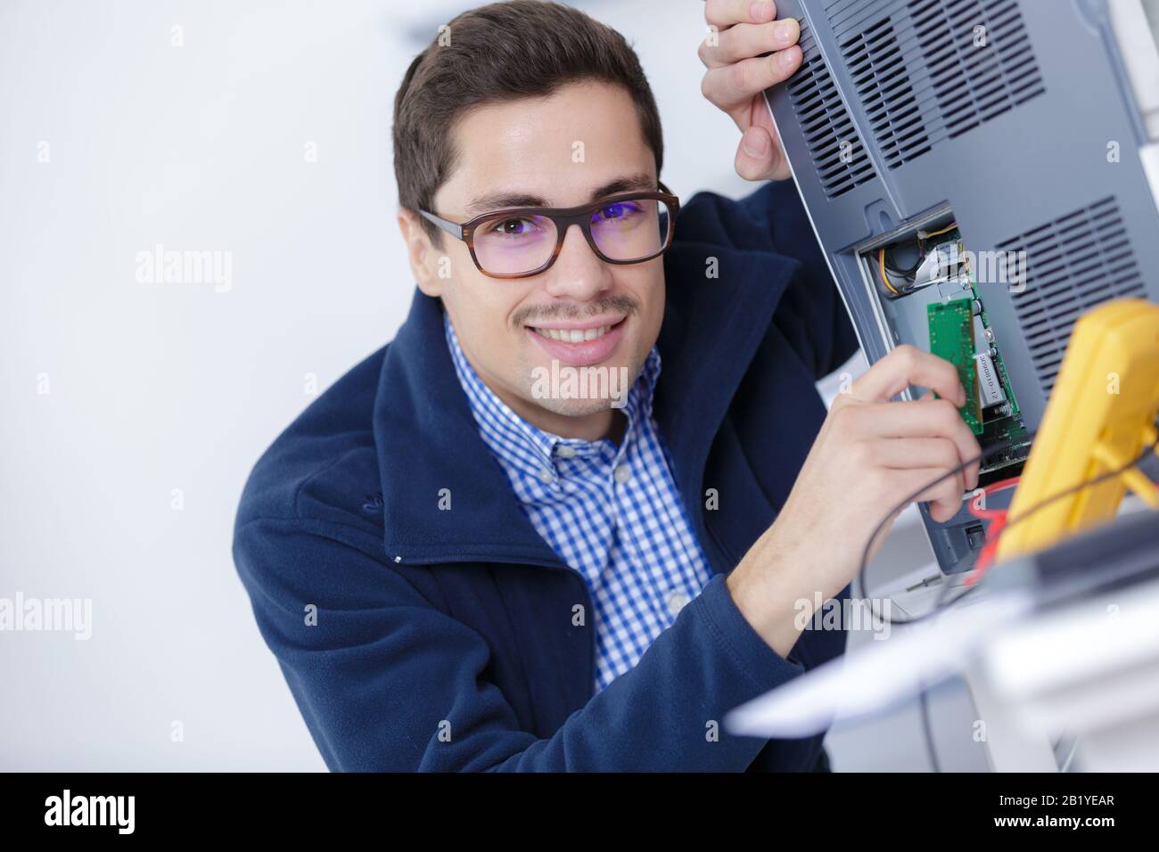 young male technician repairing digital photocopier machine Stock Photo ...