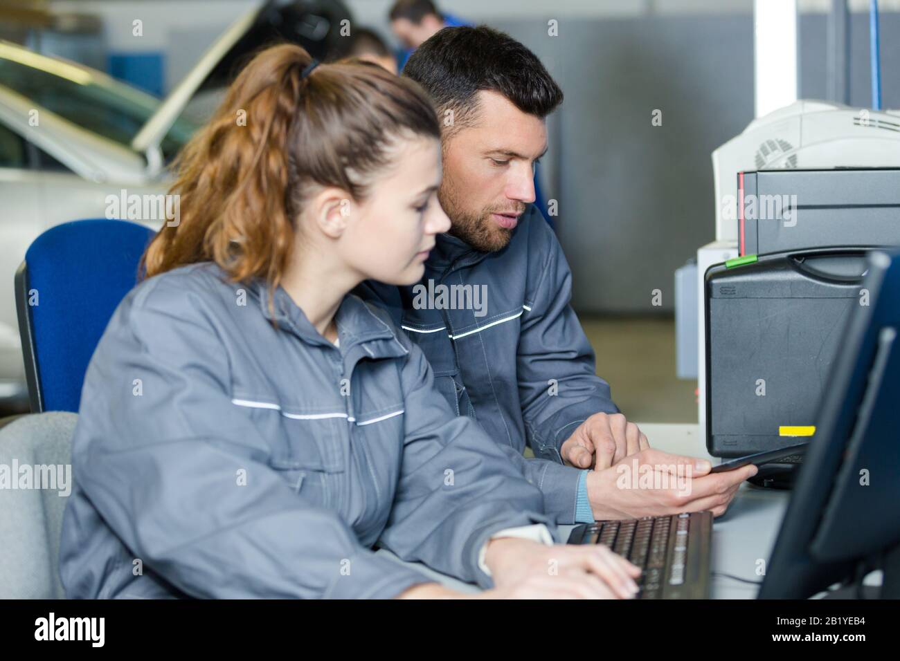 woman and man mechanic typing on a computer Stock Photo - Alamy