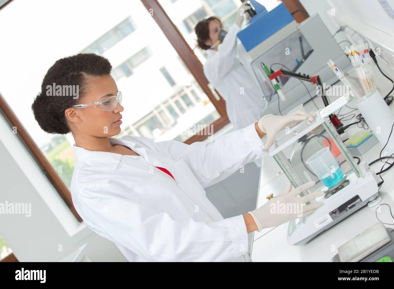 attractive young scientist looking at the microscope Stock Photo - Alamy