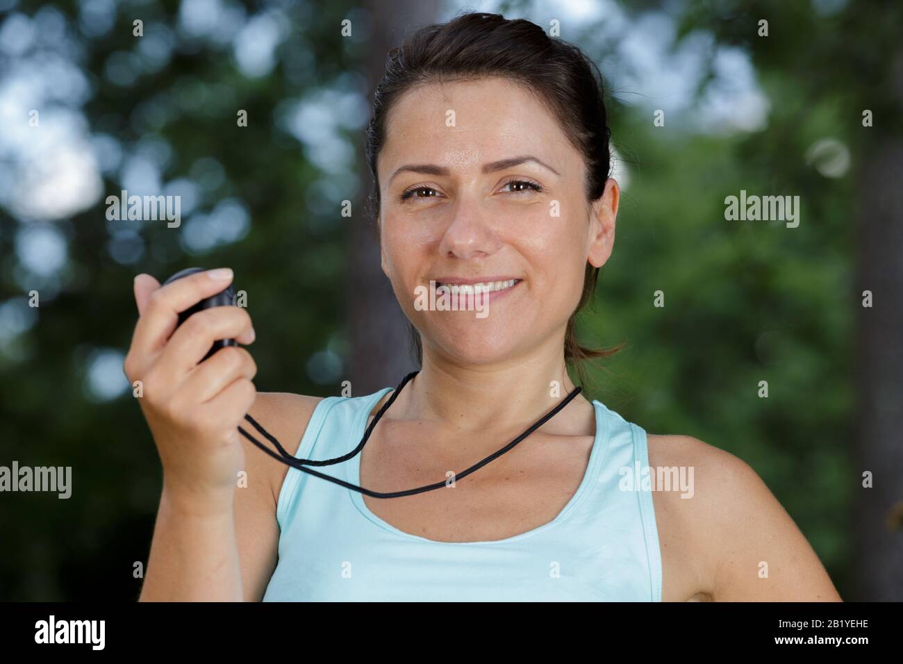 female coach timing runner in a park Stock Photo - Alamy
