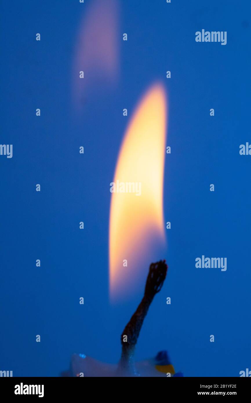 A Close Up of a Single Candle Flame and Wick on Coloured Background ...