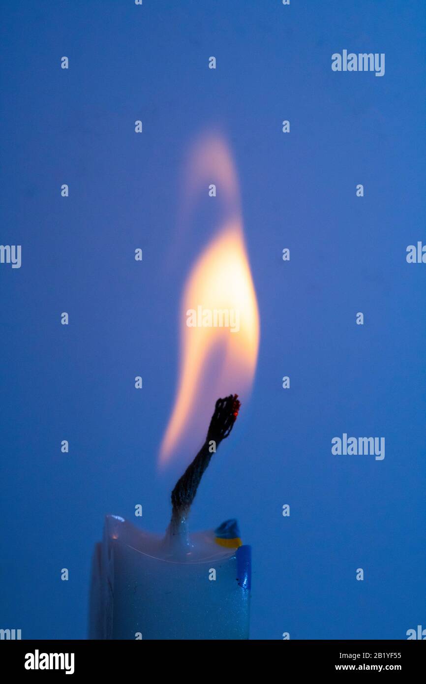 A Close Up of a Single Candle Flame and Wick on Coloured Background ...