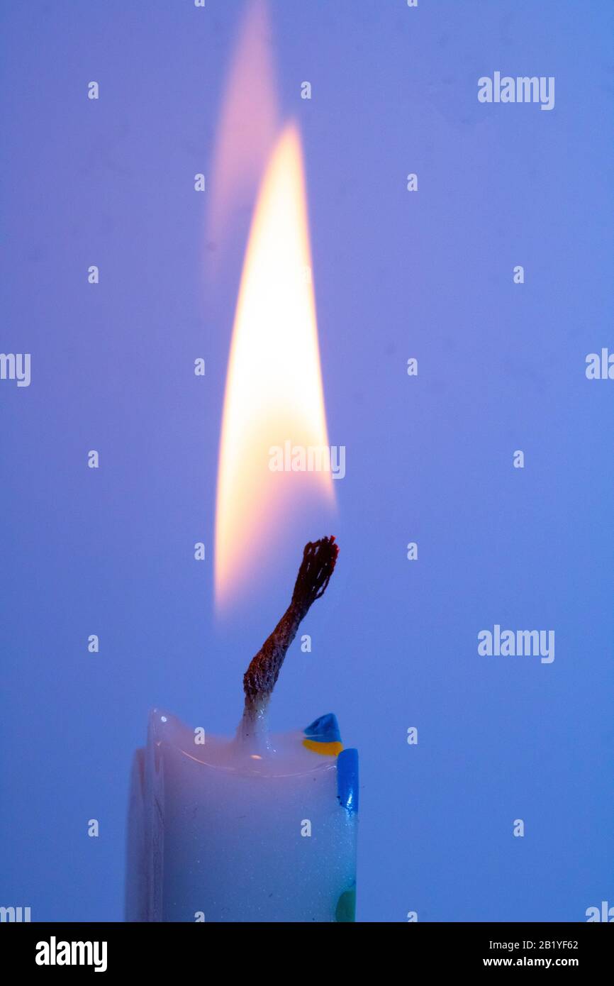 A Close Up of a Single Candle Flame and Wick on Coloured Background ...