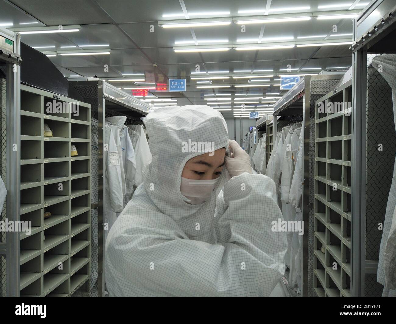 Chinese workers put on dust-proof clothing before entering the work ...