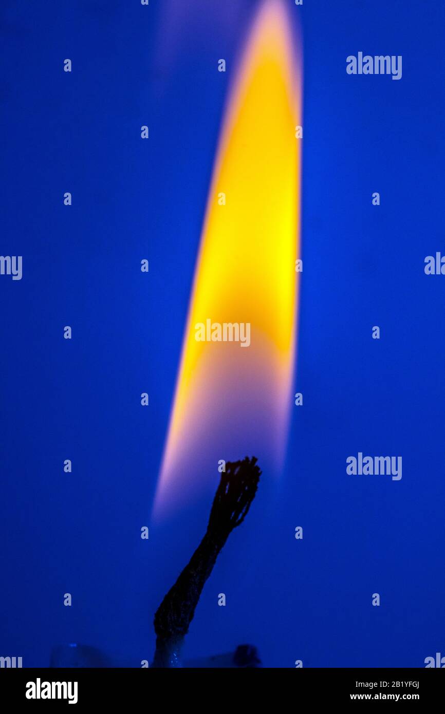 A Close Up of a Single Candle Flame and Wick on Coloured Background ...