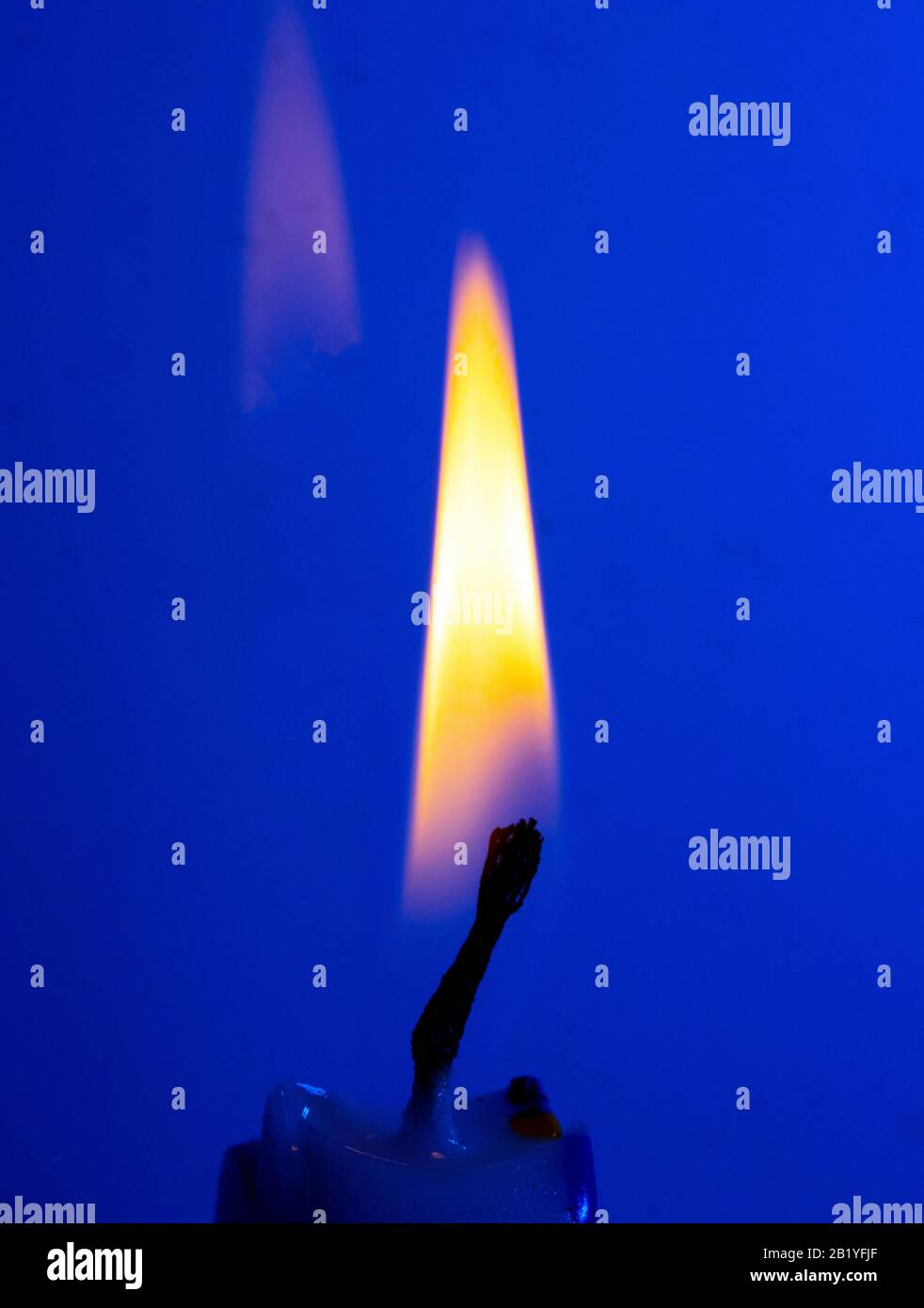 A Close Up of a Single Candle Flame and Wick on Coloured Background ...