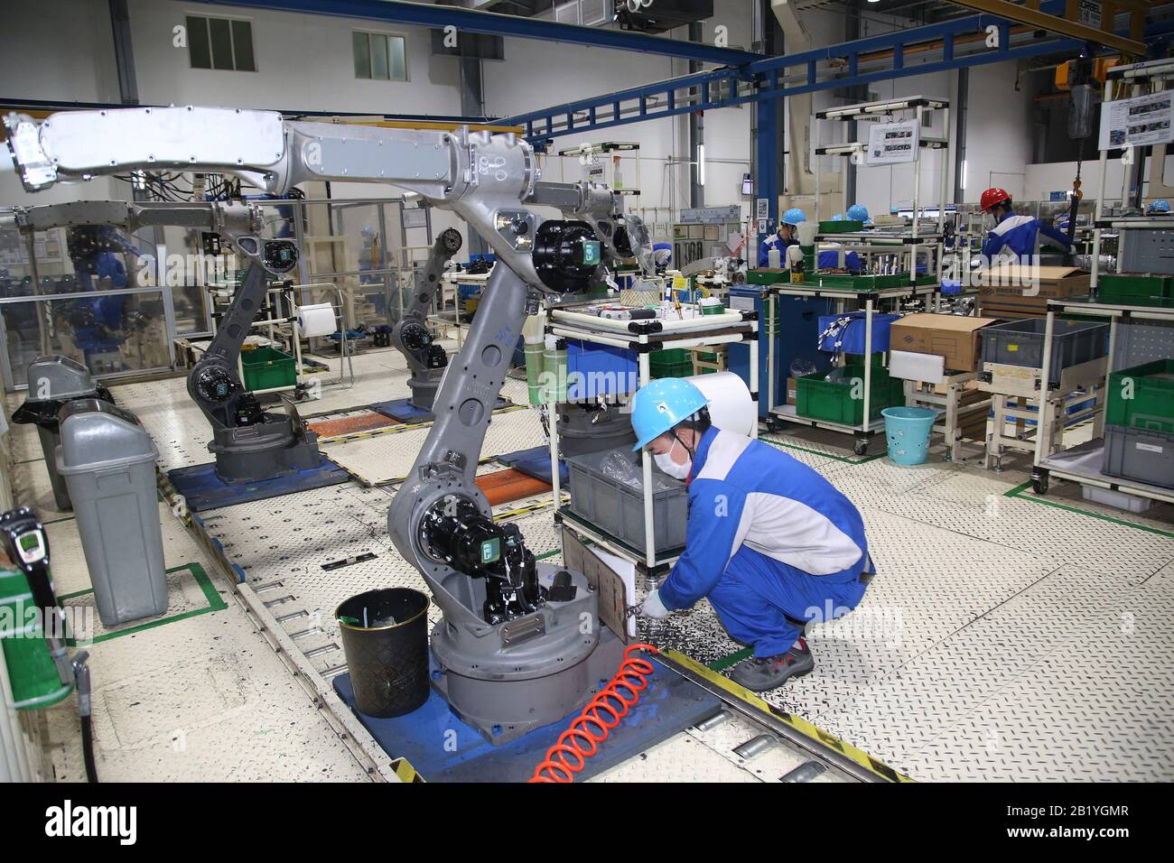 Chinese workers manufacture robot arms at the plant of Yaskawa Electric ...